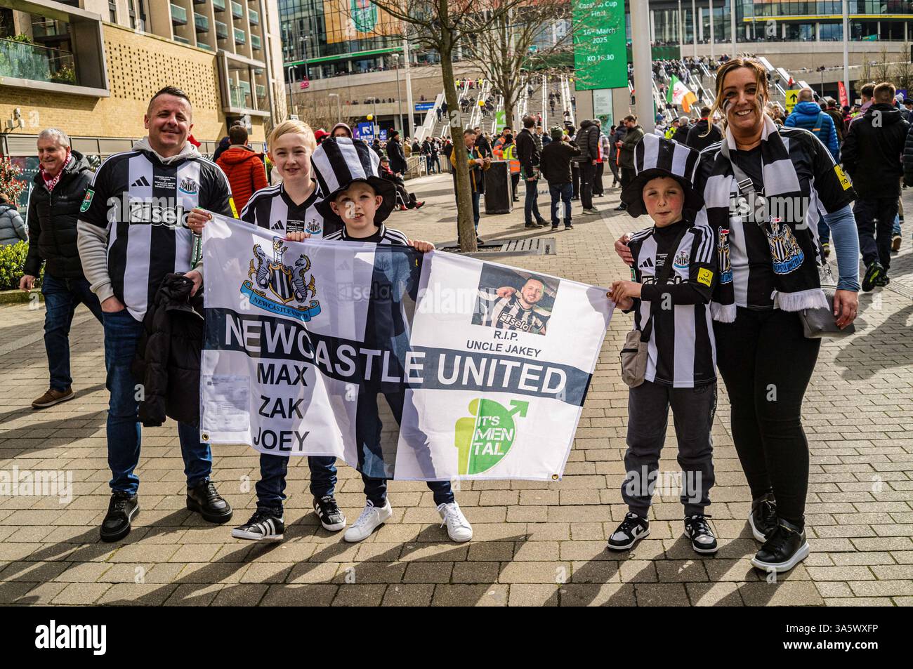 A family poses outside Wembley Stadium with their flag. On the ...