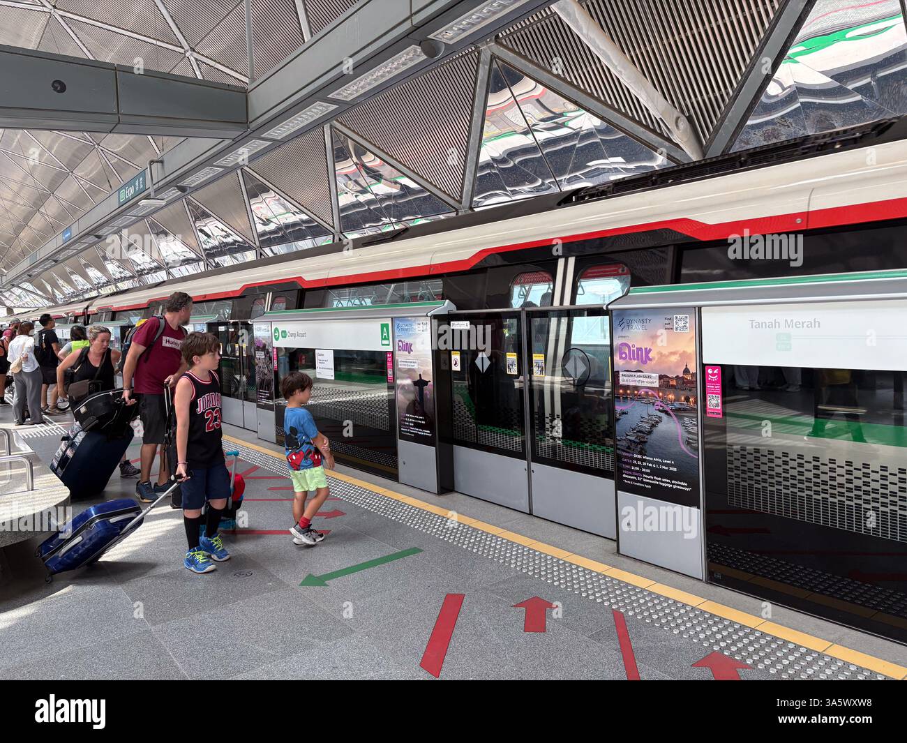 The platform of a Singapore Mass Rapid Transit (MRT) station with people and a train Stock Photo ...