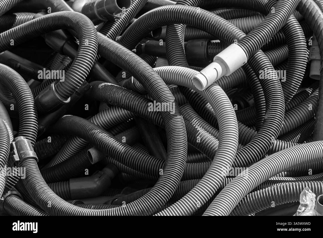 Pile of black plastic vacuum cleaner hoses outside on a market Stock ...