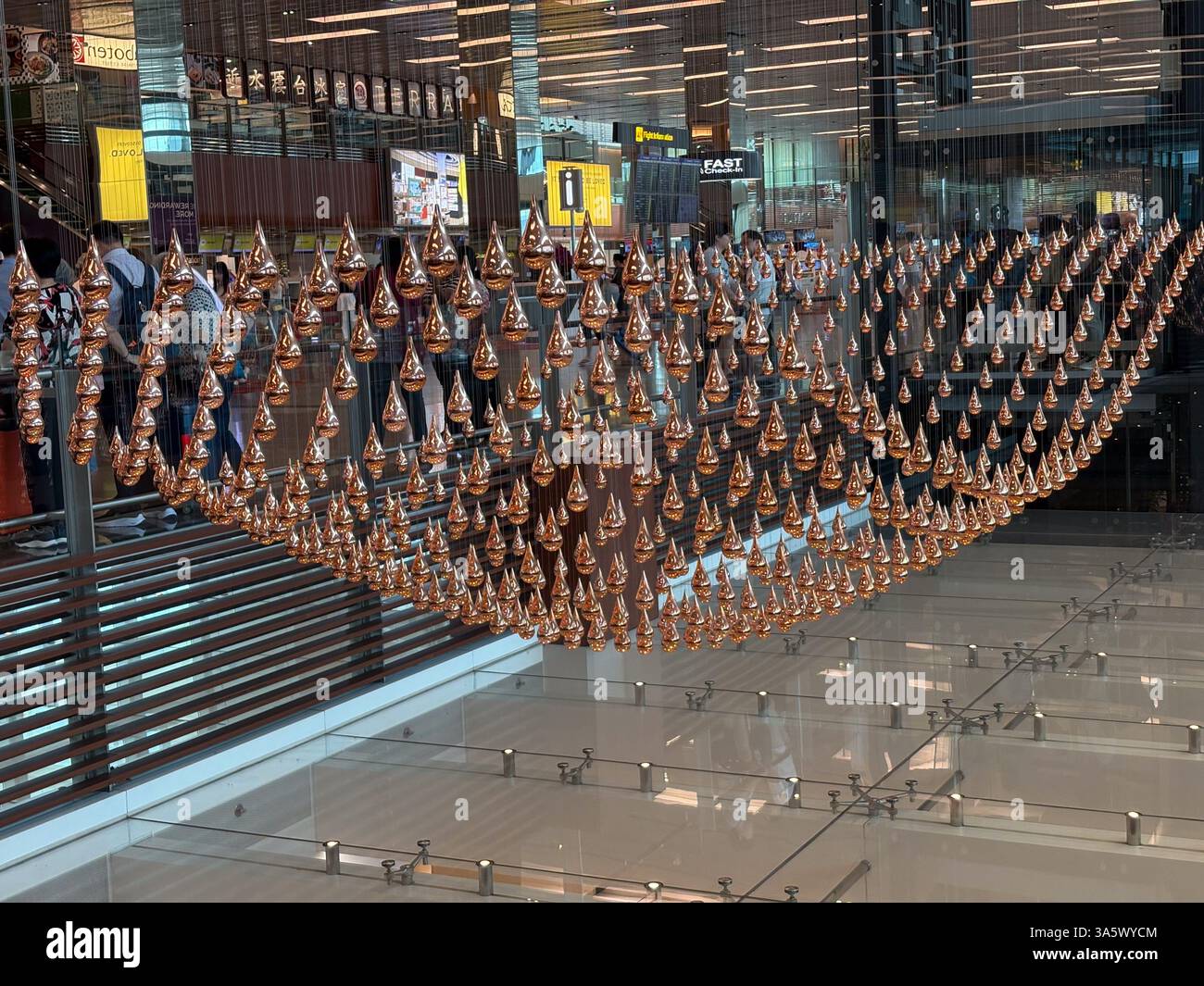 The kinetic rain art display consists of numerous suspended bronze droplets that move in ...