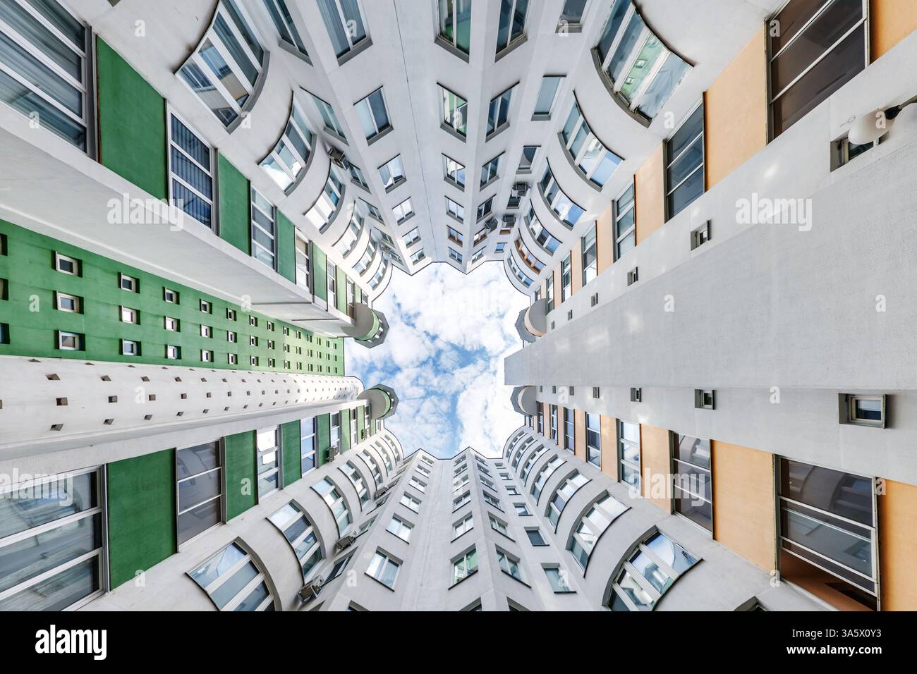view from bottom up to the sky in a skyscraper house well with a narrow ...