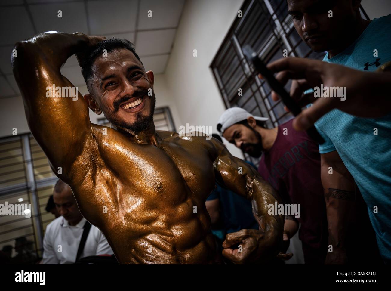 March 23, 2025: A male participant gets his body painted with tanning ...