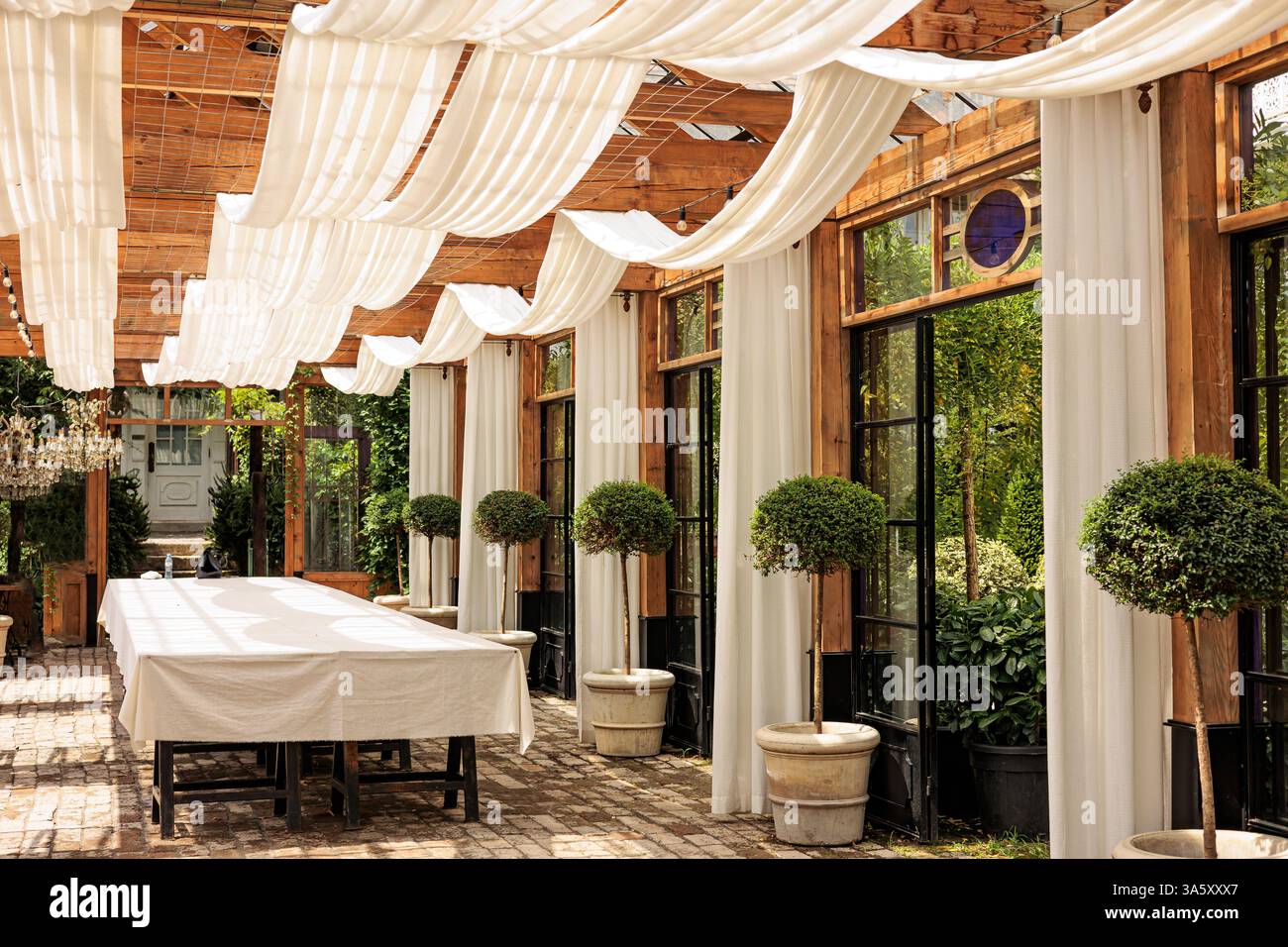 Cozy summer veranda featuring wooden accents, a long table with a white ...