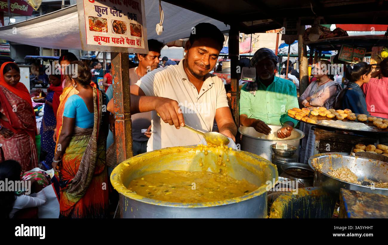 A street food vendor serving dishes of matar (chickpea) curry in Gaya ...