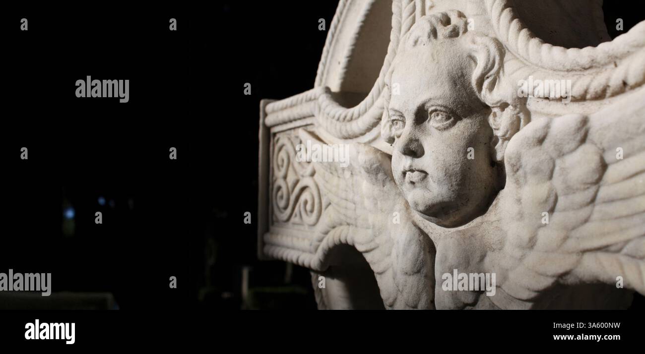 Cherub face carved into sacred cross-shaped tombstone Stock Photo - Alamy