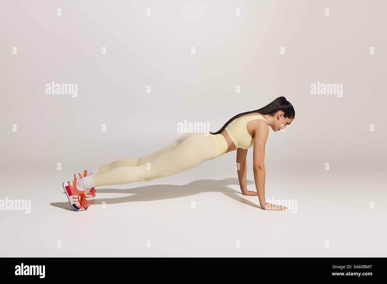 Beautiful athletic woman engages in a focused workout routine, showcasing strength and form ...