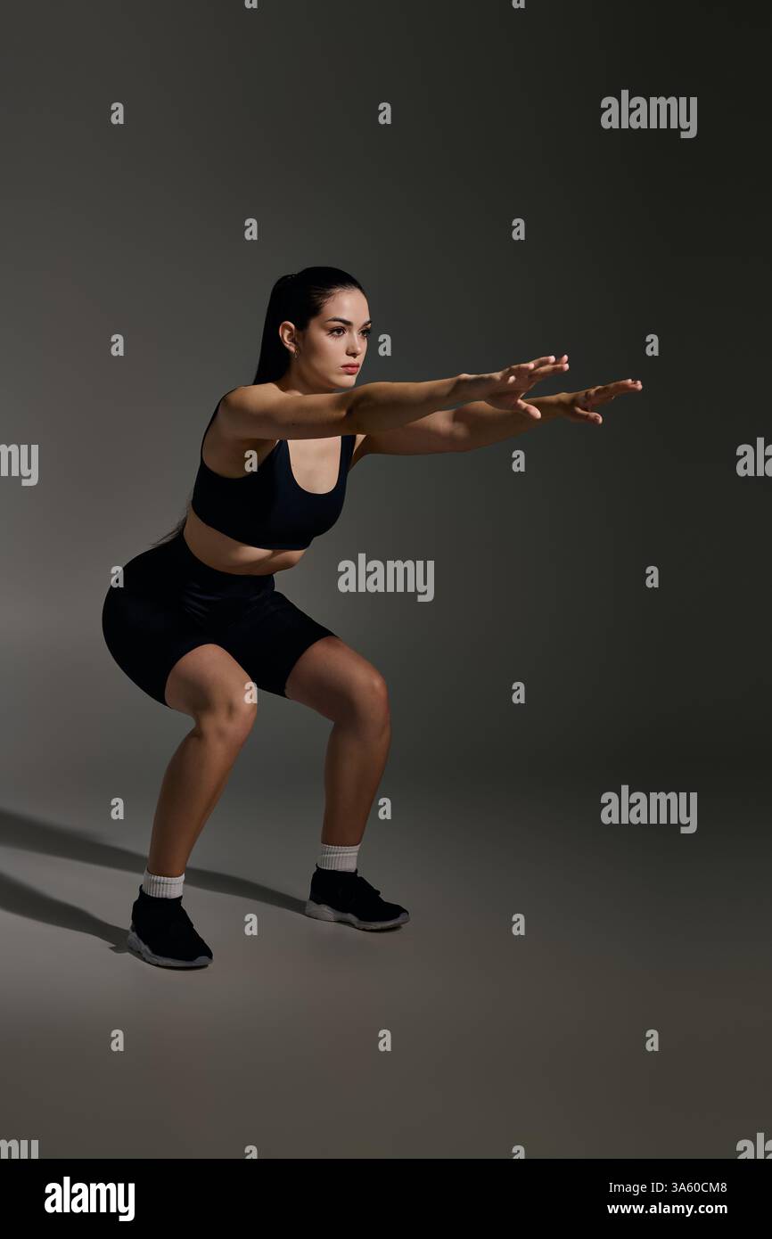 A young beautiful athlete engages in strength training, focused on her form and technique Stock ...