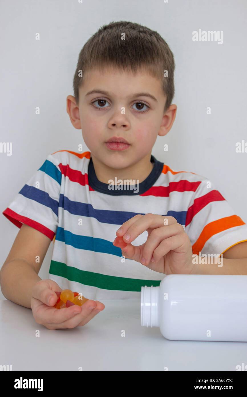 The boy eats jelly beans or takes vitamins Stock Photo - Alamy
