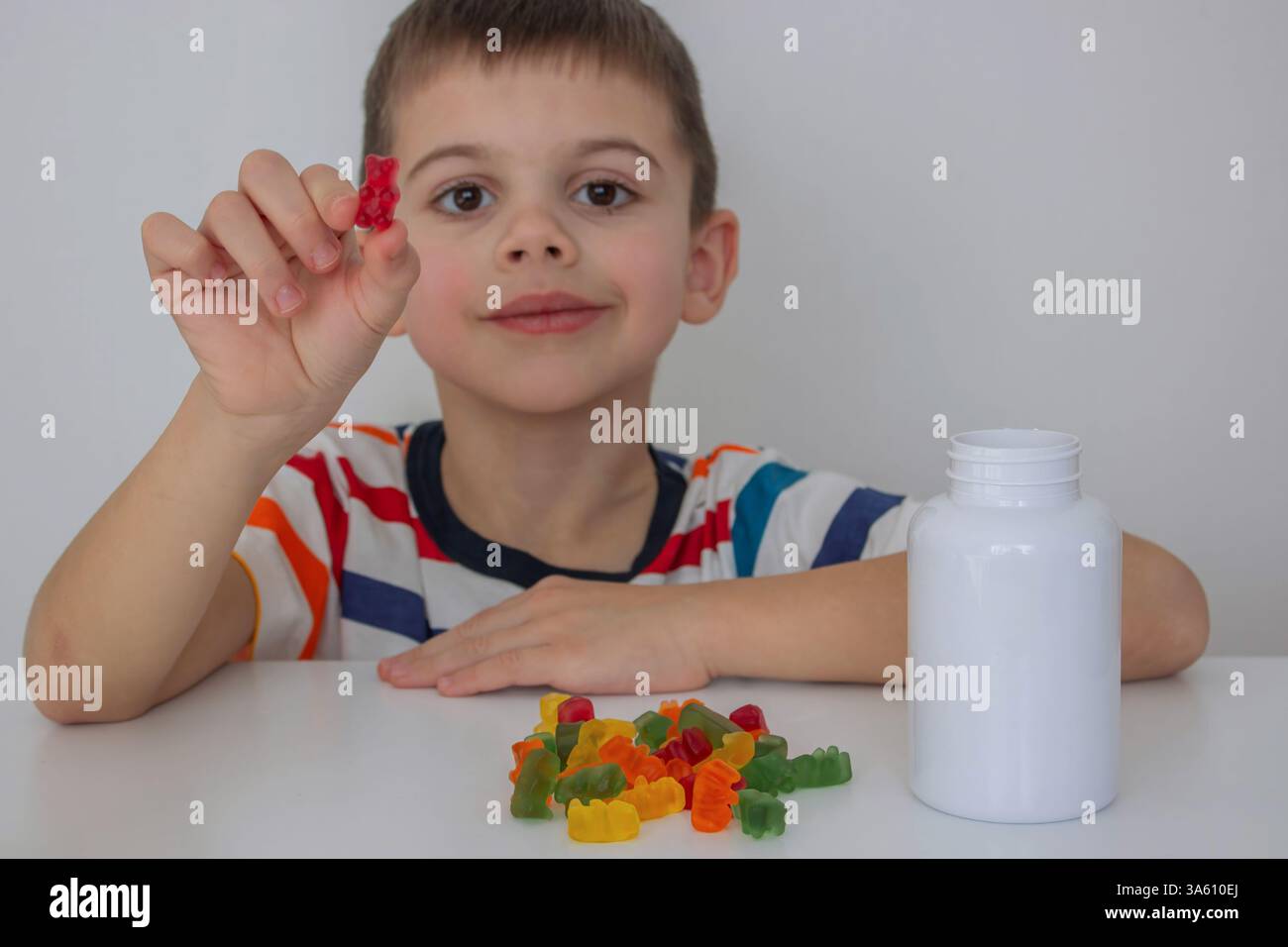 The boy eats jelly beans or takes vitamins Stock Photo - Alamy