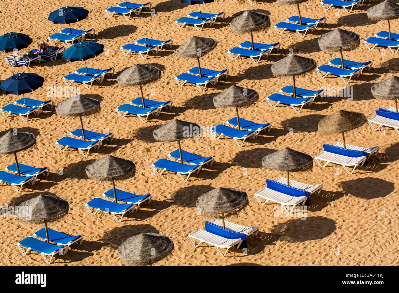 Cliffside, beachgoers and umbrellas at Praia dos Pescadores or ...