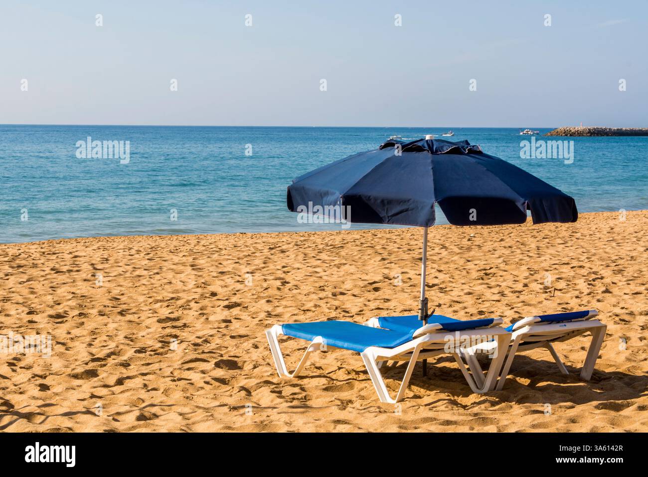 Cliffside, beachgoers and umbrellas at Praia dos Pescadores or ...