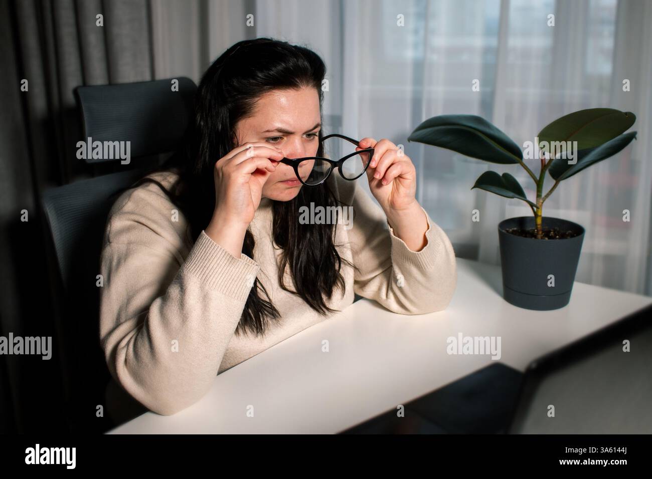 Office worker woman trying to read text from monitor using eyeglasses ...
