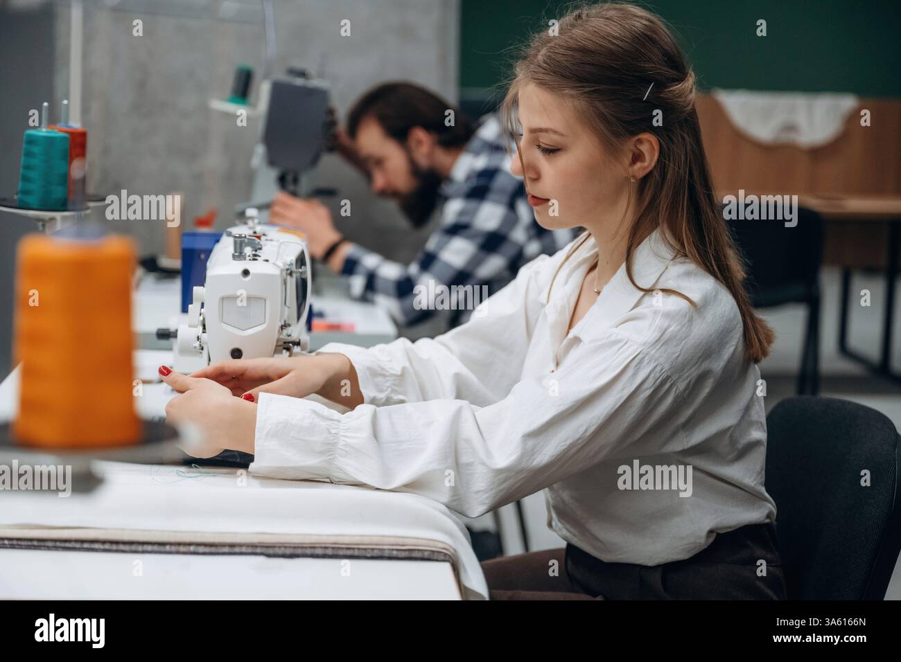 View from the side, sitting. People are working by the sewing machines ...