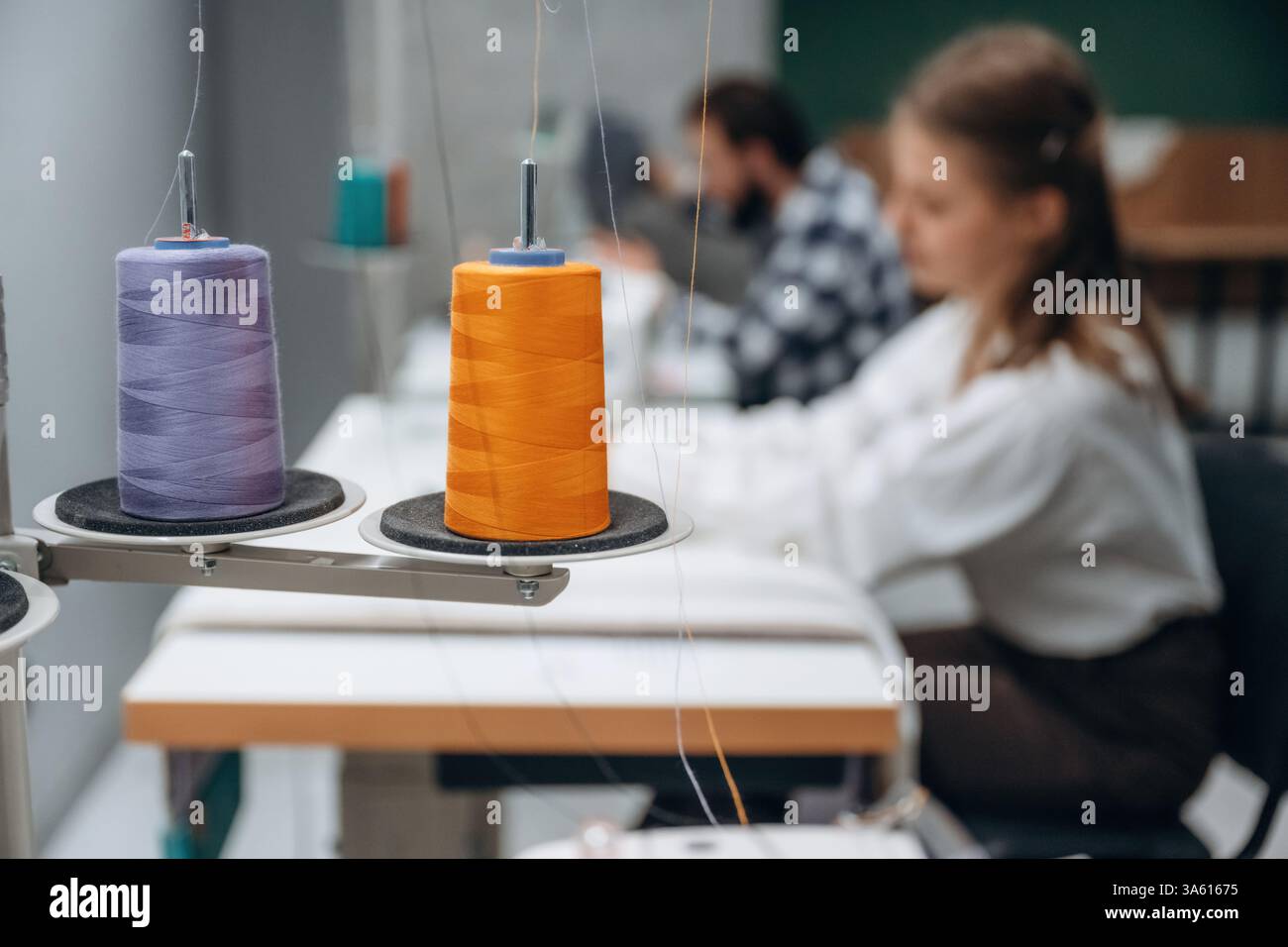 View from the side, sitting. People are working by the sewing machines ...
