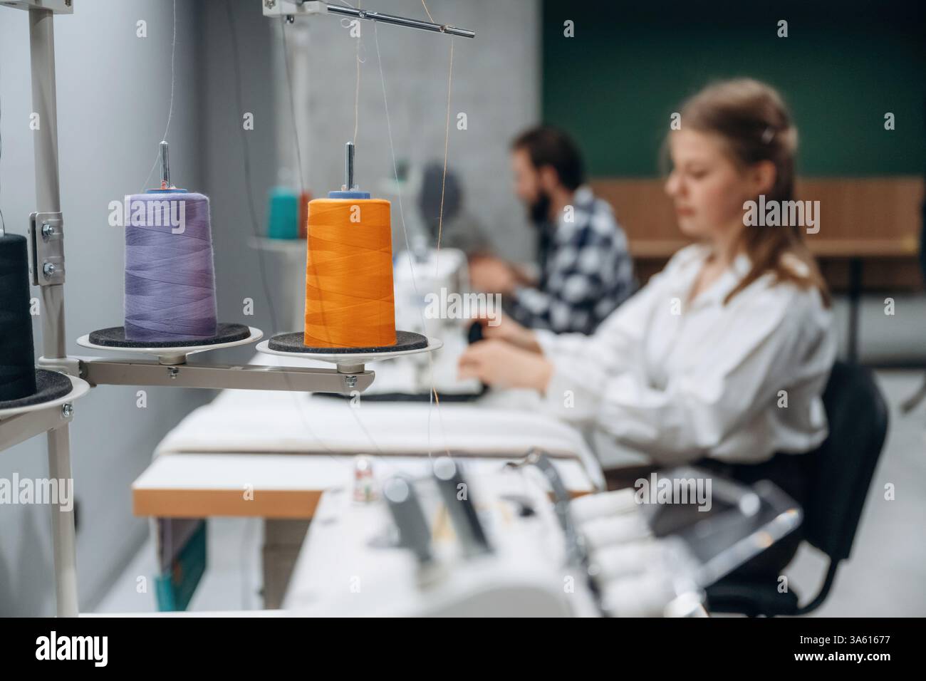 View from the side, sitting. People are working by the sewing machines ...