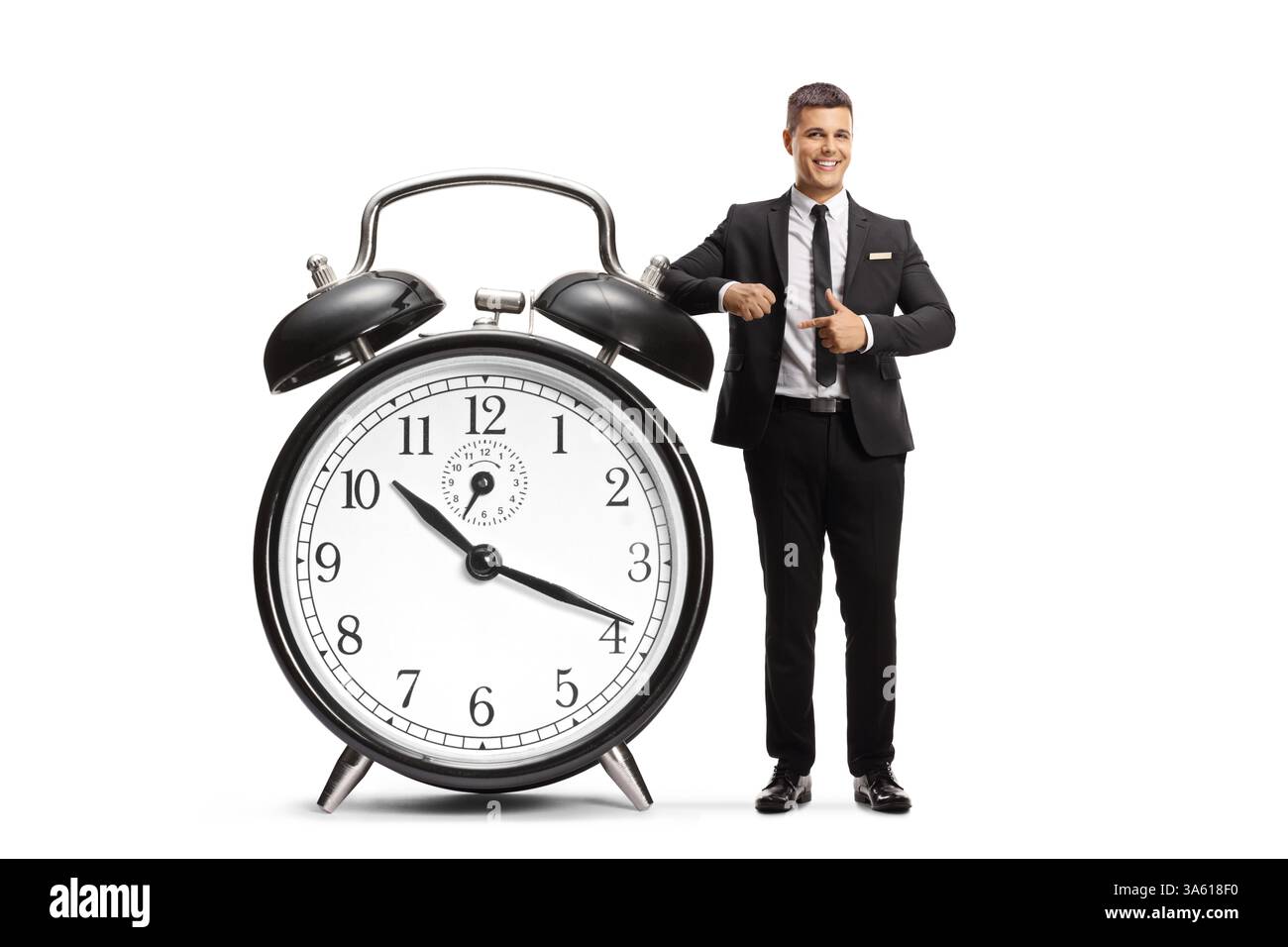 Man in a suit and tie leaning pointing at a big alarm clock isolated on ...
