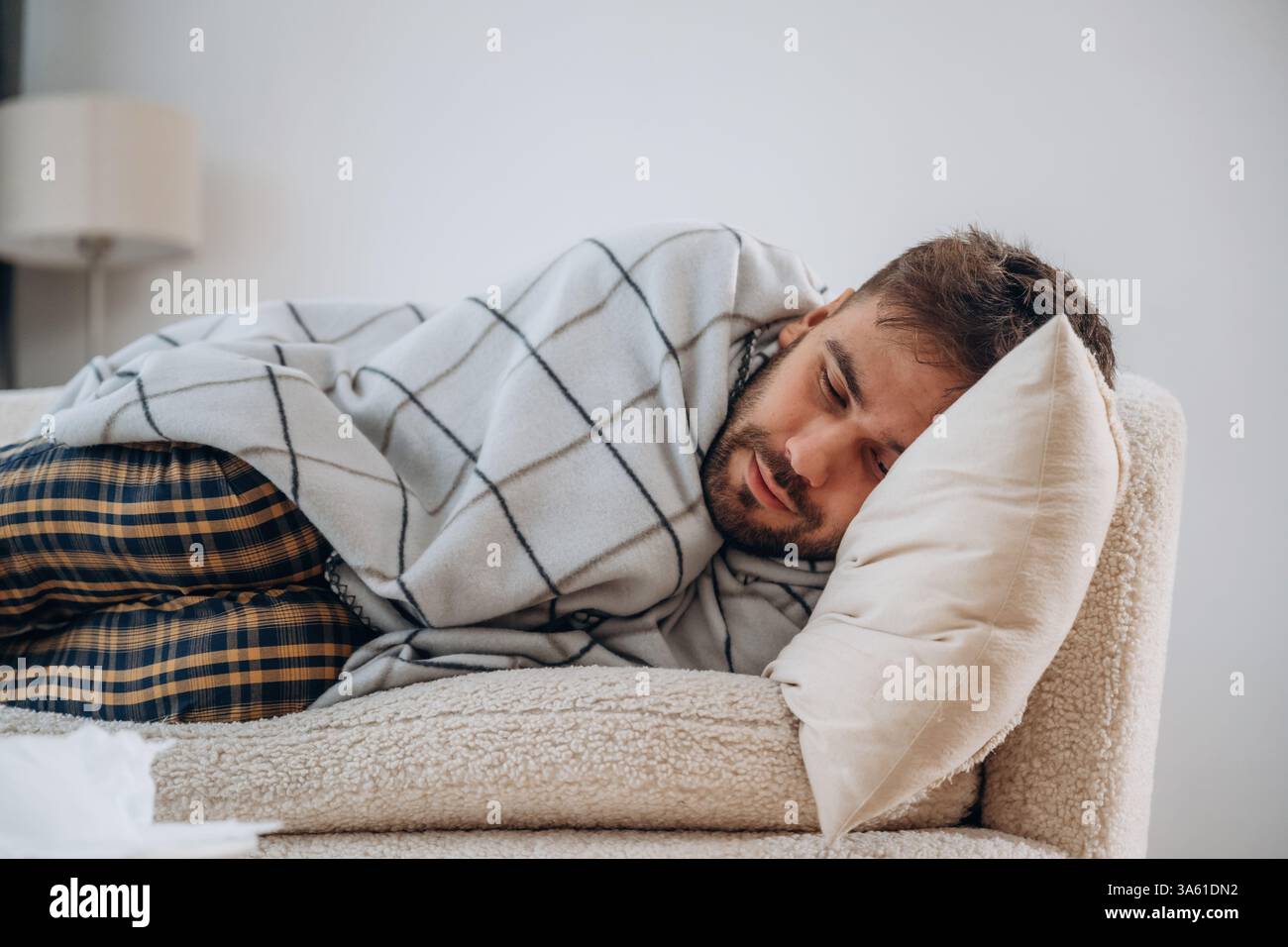 Cold, lying down under the blanket. Sick man is feeling bad at home ...