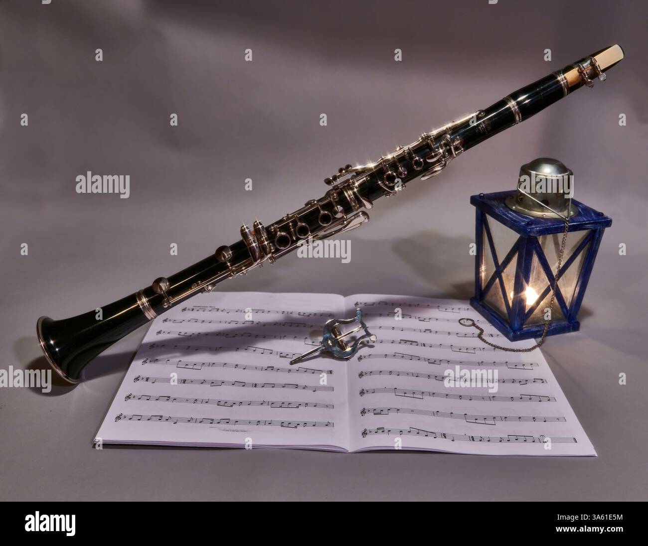 Clarinet still life on sheet music with a little music stand and candle ...
