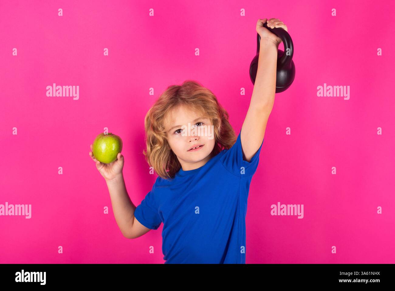 Healthy kids. Cute child boy pumping up arm muscles with kettlebell. Fitness kids with ...