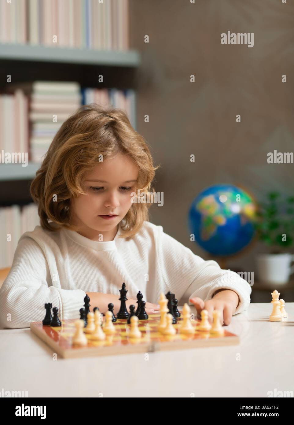 Clever concentrated and thinking kid boy playing chess Stock Photo - Alamy