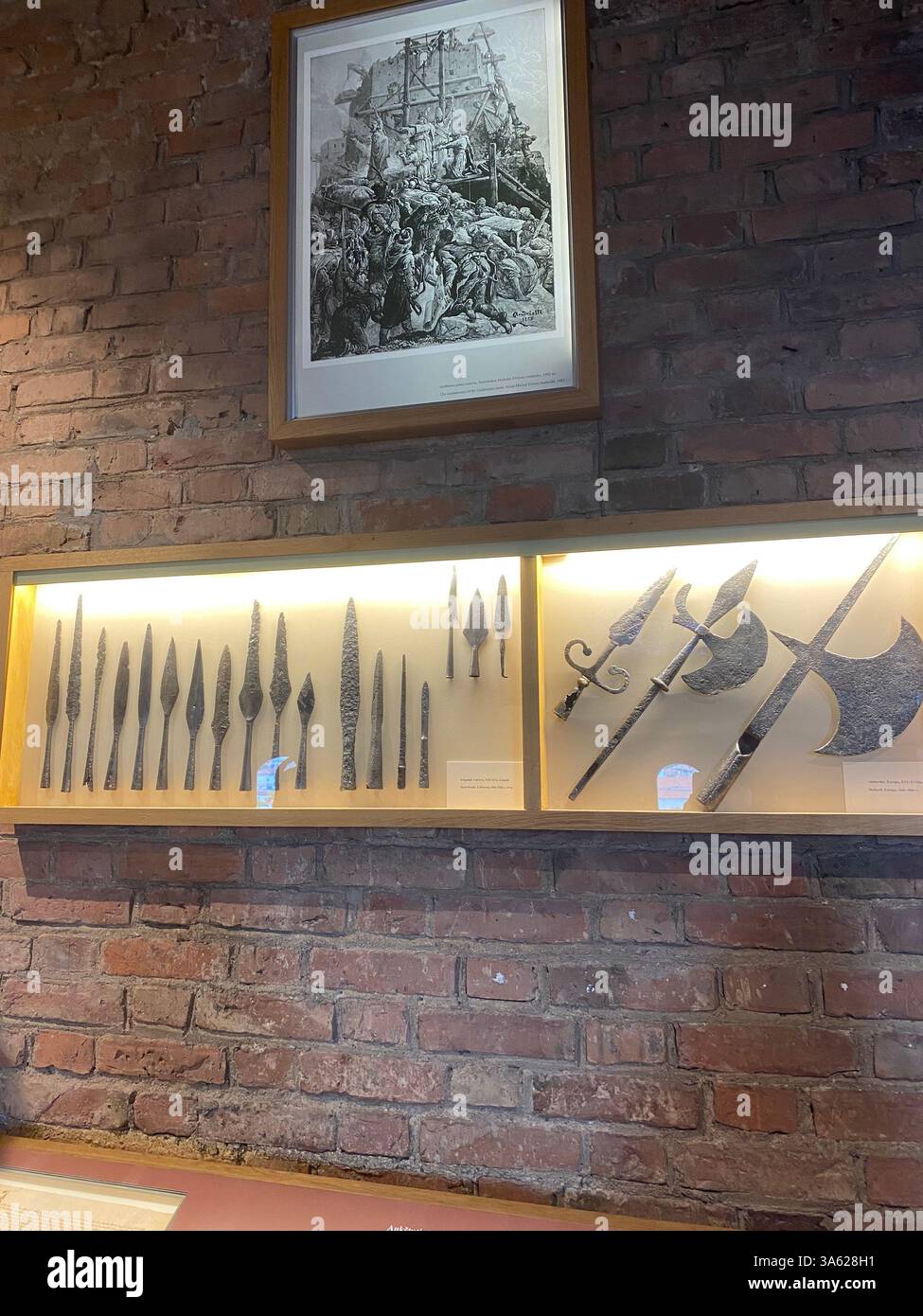 A display case on the wall with antique weapons at a museum in the ...