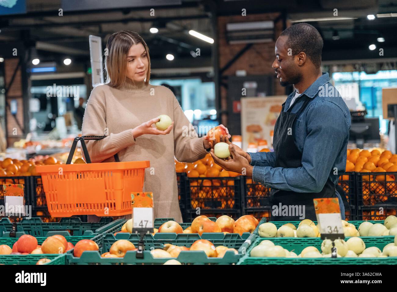 Fresh apples. Worker is helping woman with choice of products Stock ...