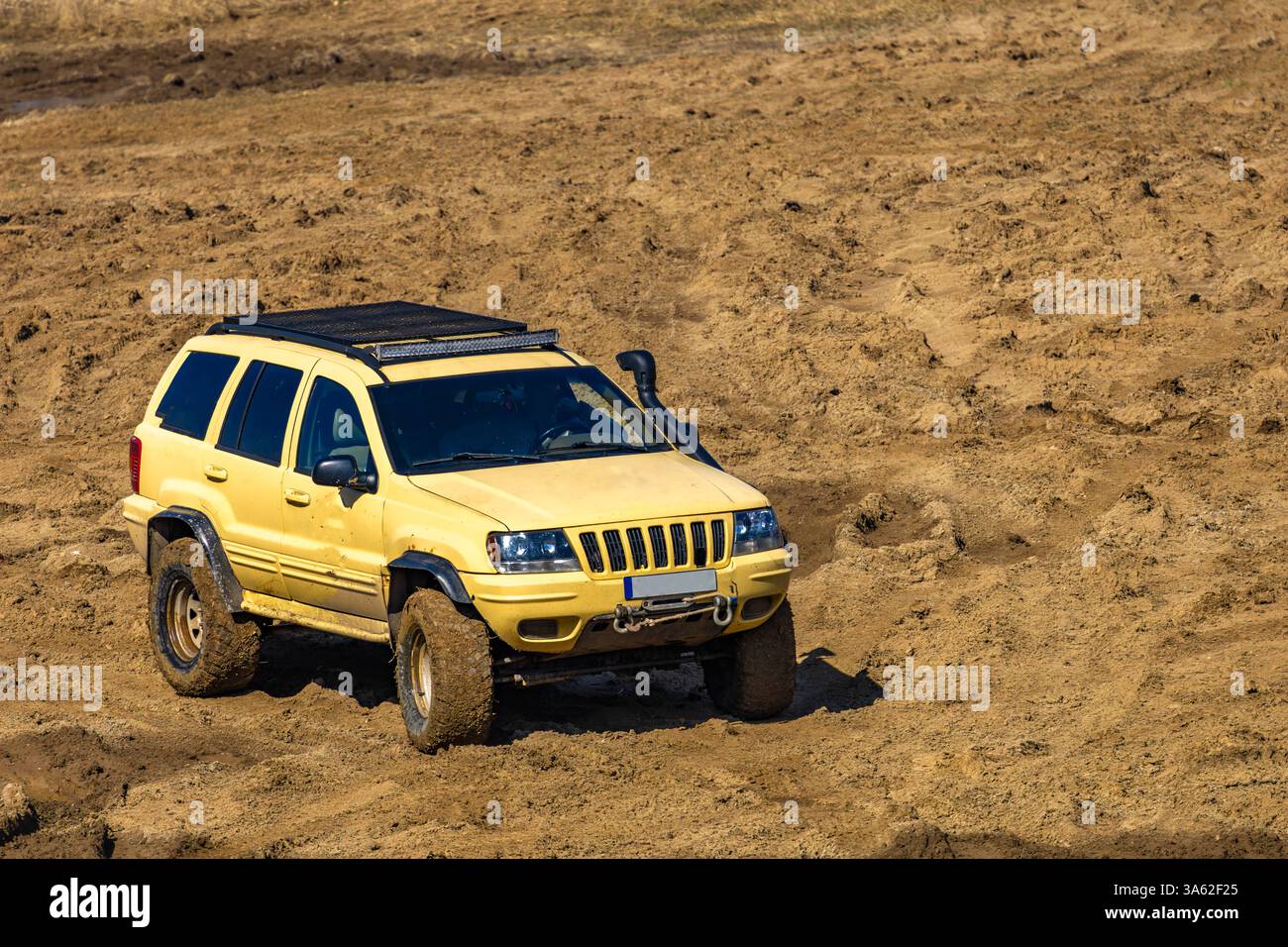 Yellow off-road vehicle at the start of a car race in the desert, sandy ...