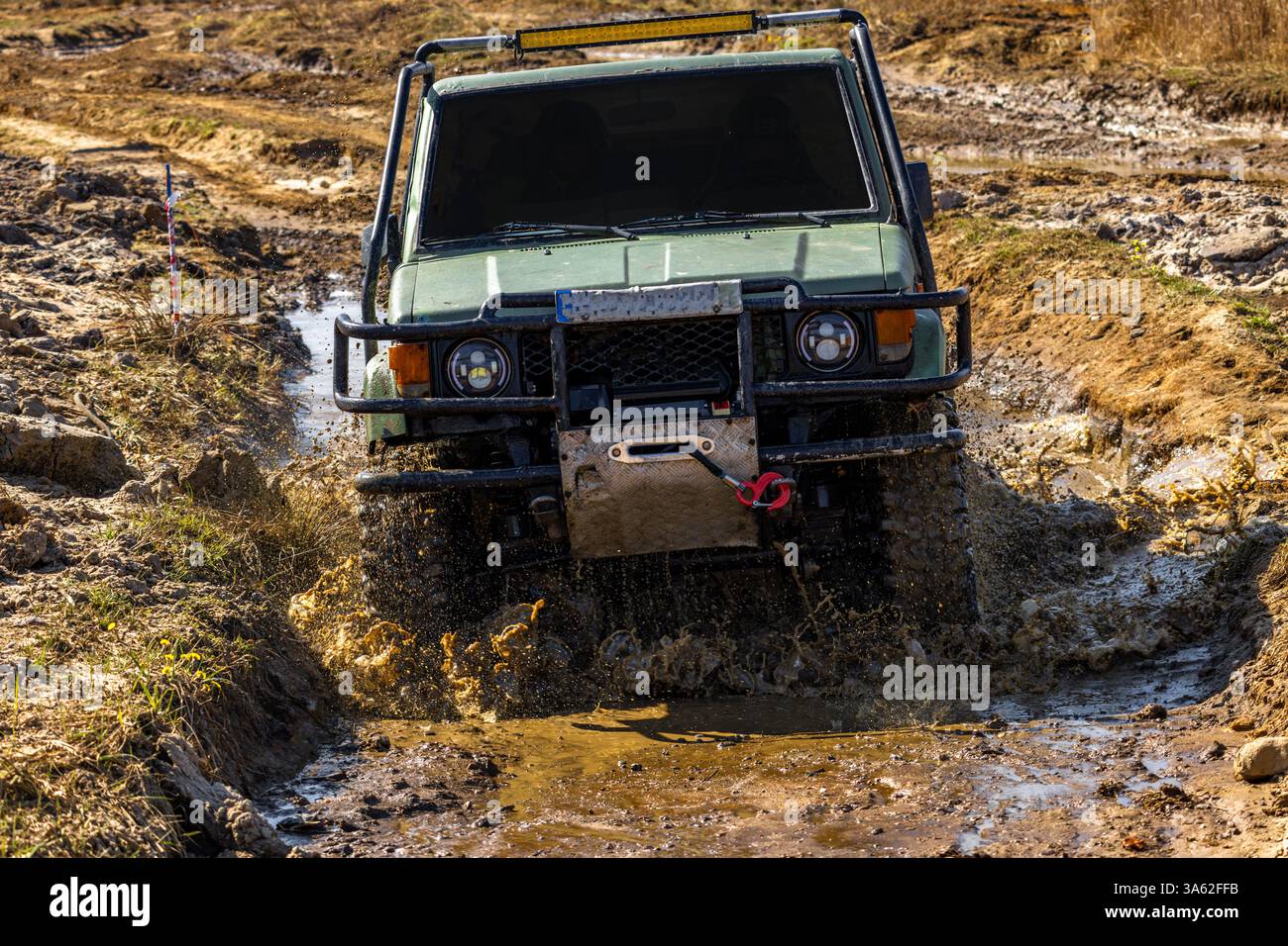Green off-road car, vehicle buried in deep mud, off-road competition ...