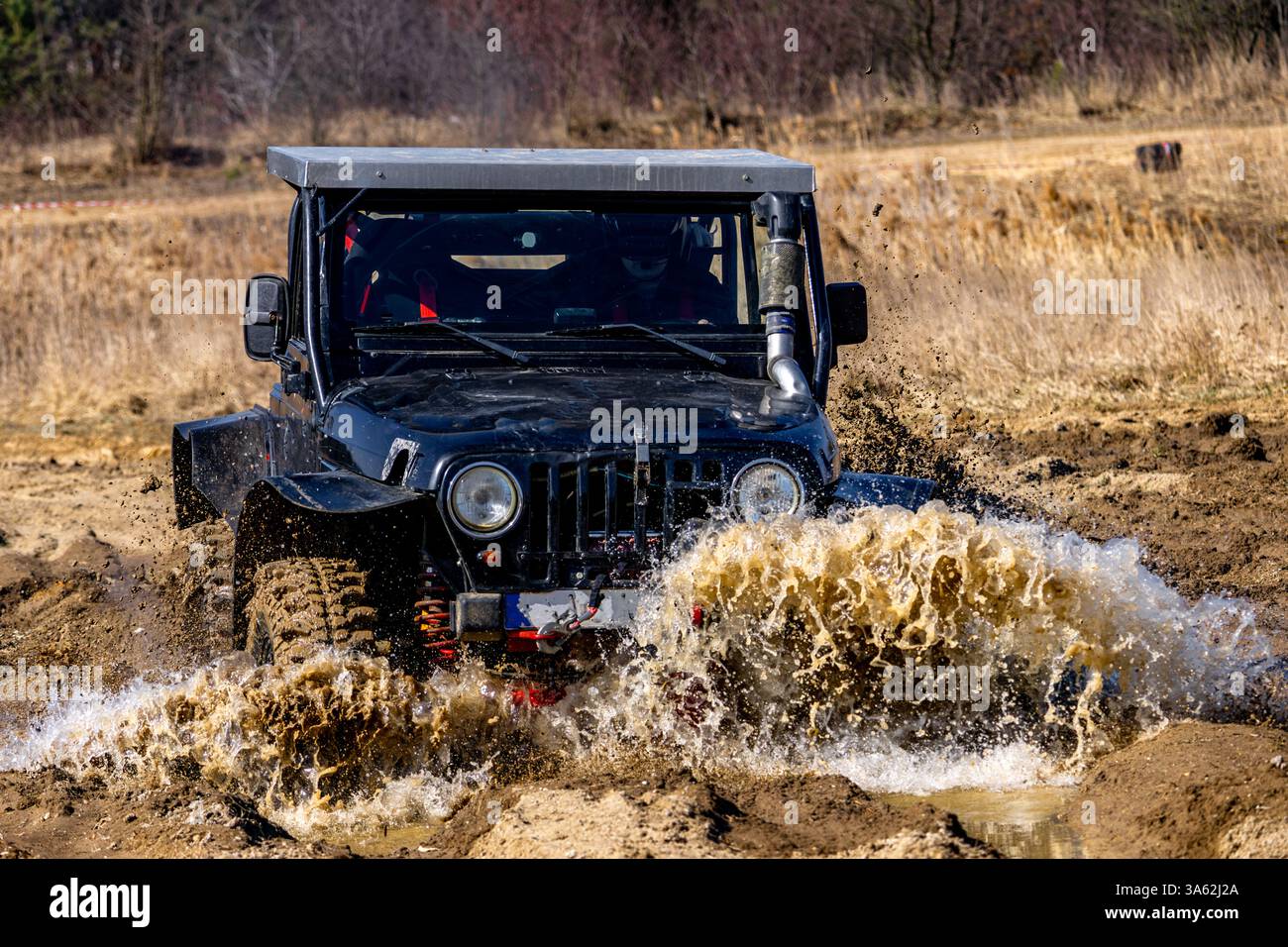 Black off-road vehicle during a field test outside the city, crossing a ...