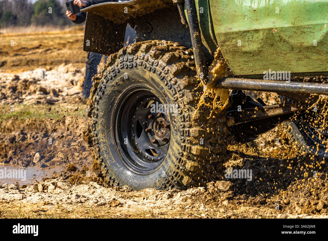 Green off-road car, vehicle buried in deep mud, off-road competition ...