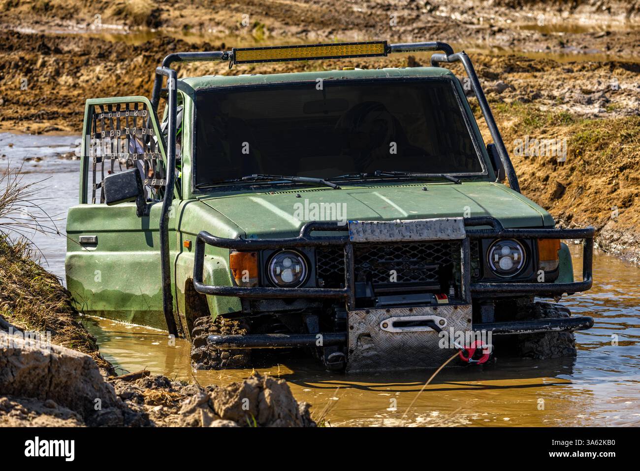 Green off-road car, vehicle buried in deep mud, off-road competition ...