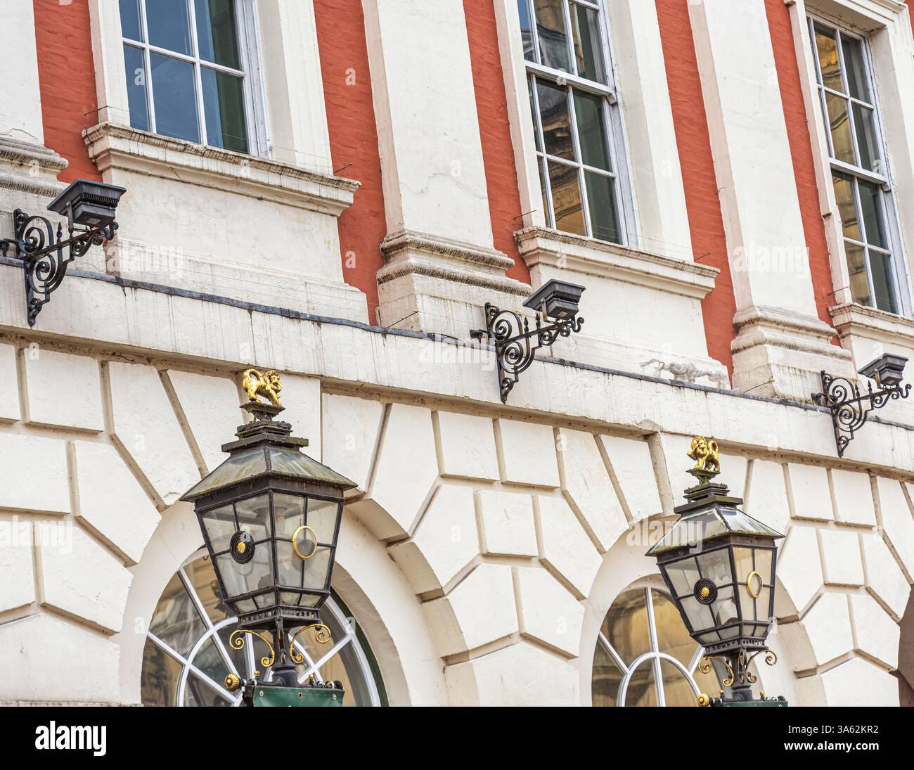 A 18th Century civic building with two lanterns set in front of some ...