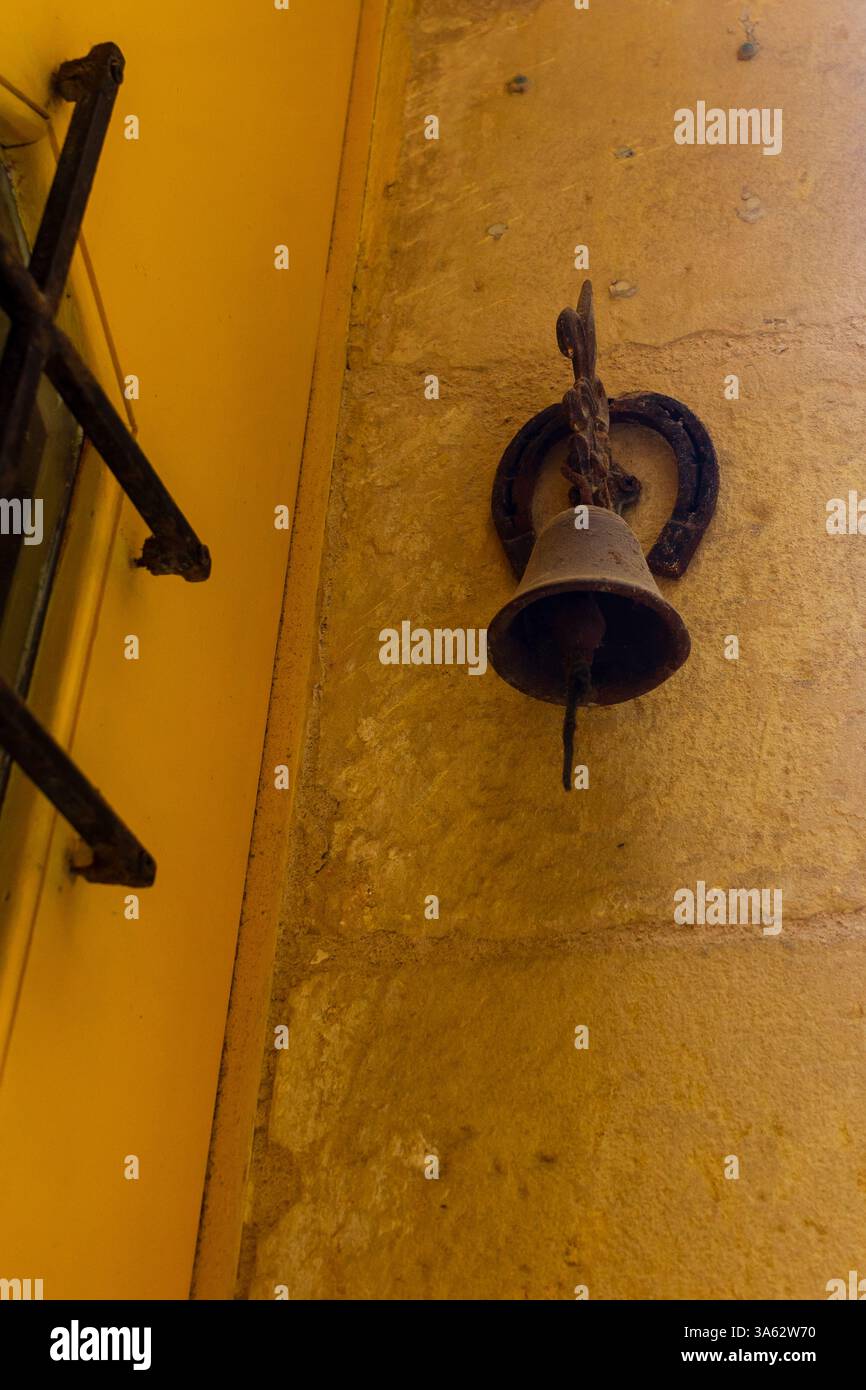 Vintage Metal Bell Mounted on Rustic Yellow Stone Wall Stock Photo - Alamy