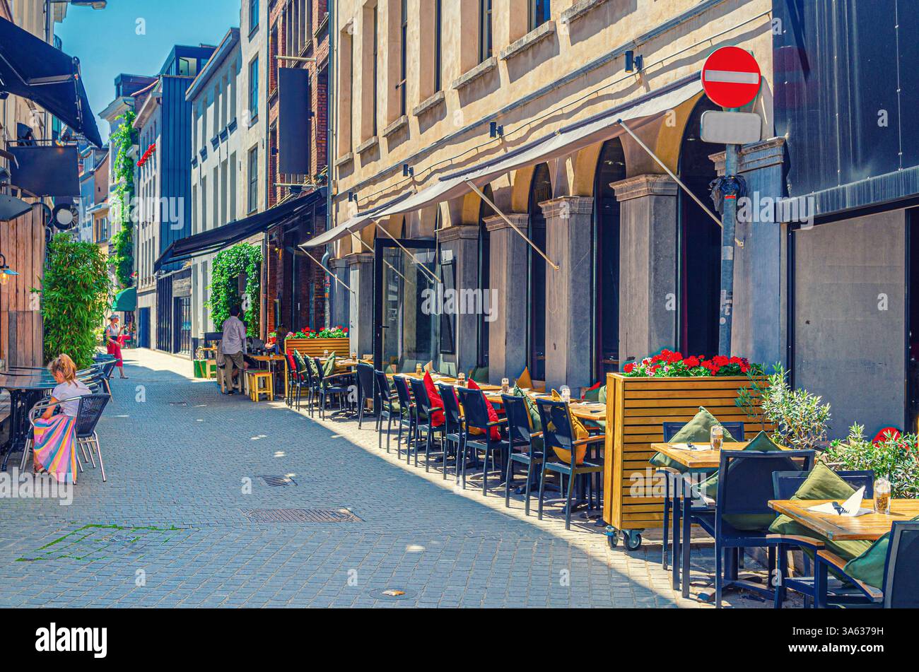 Street restaurant with tables and chairs on narrow street, road with ...