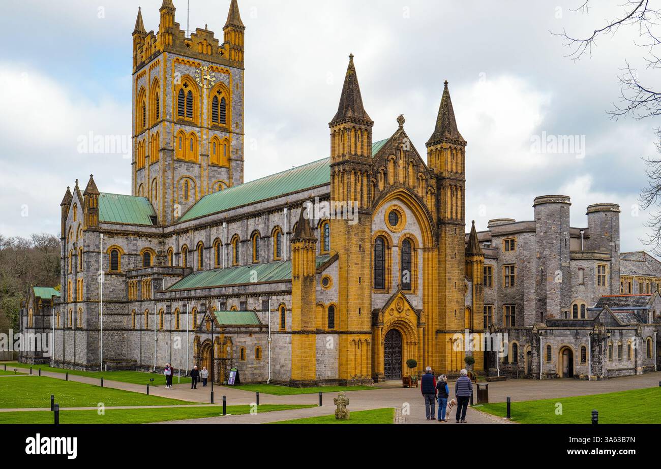 Buckfast Abbey and monastery exteriors in early Spring with people walking around the grounds ...