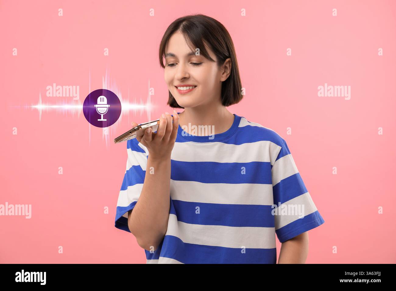 Young woman recording voice message via smartphone on pink background ...