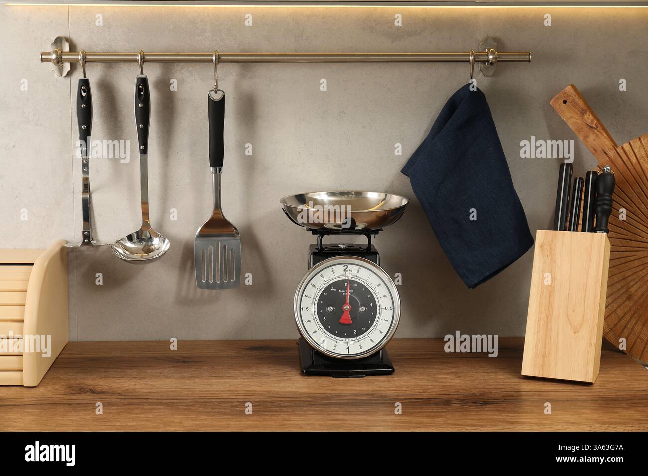 Retro mechanical kitchen scale on wooden countertop and other utensils ...