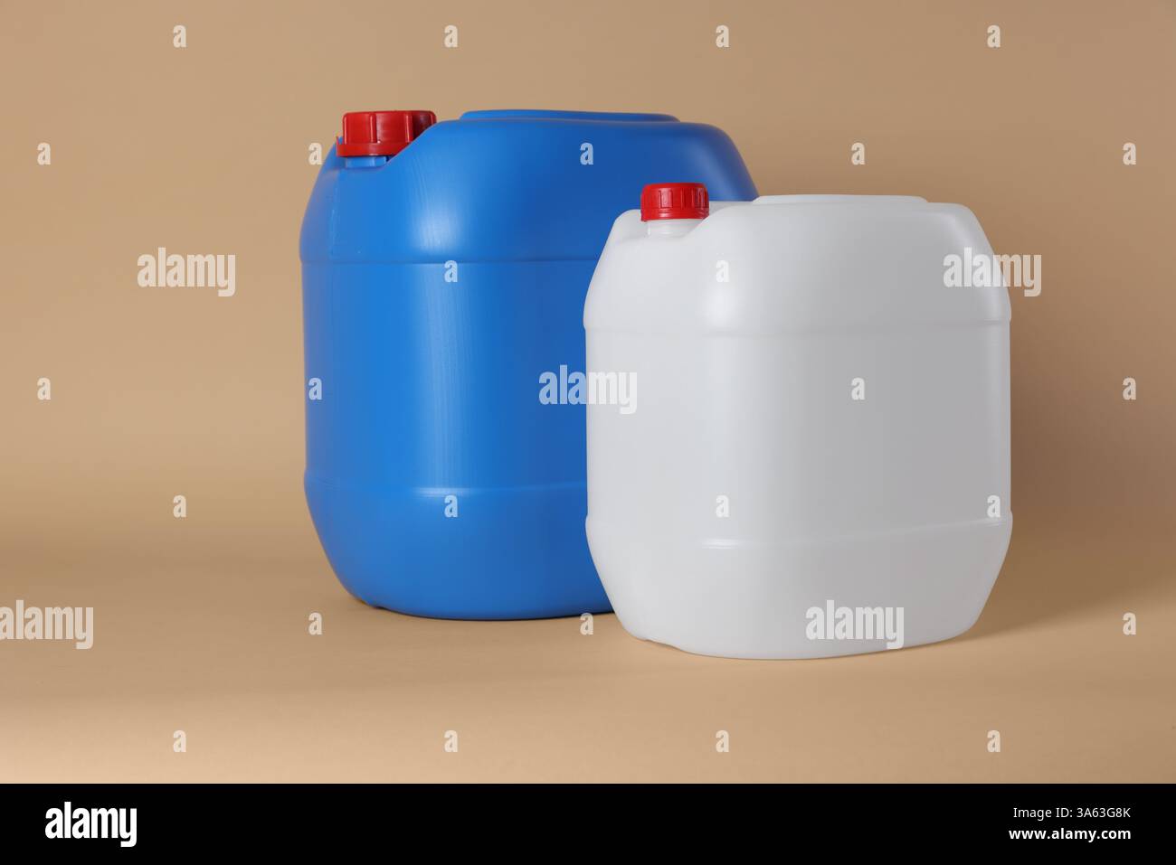 Two clean plastic canisters on beige background Stock Photo - Alamy