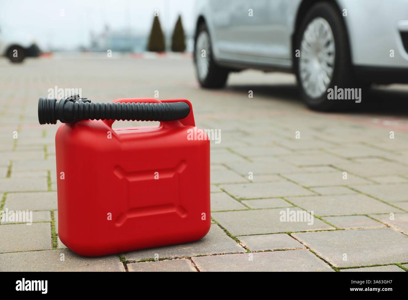 Red plastic canister with spout on pavement outdoors Stock Photo - Alamy