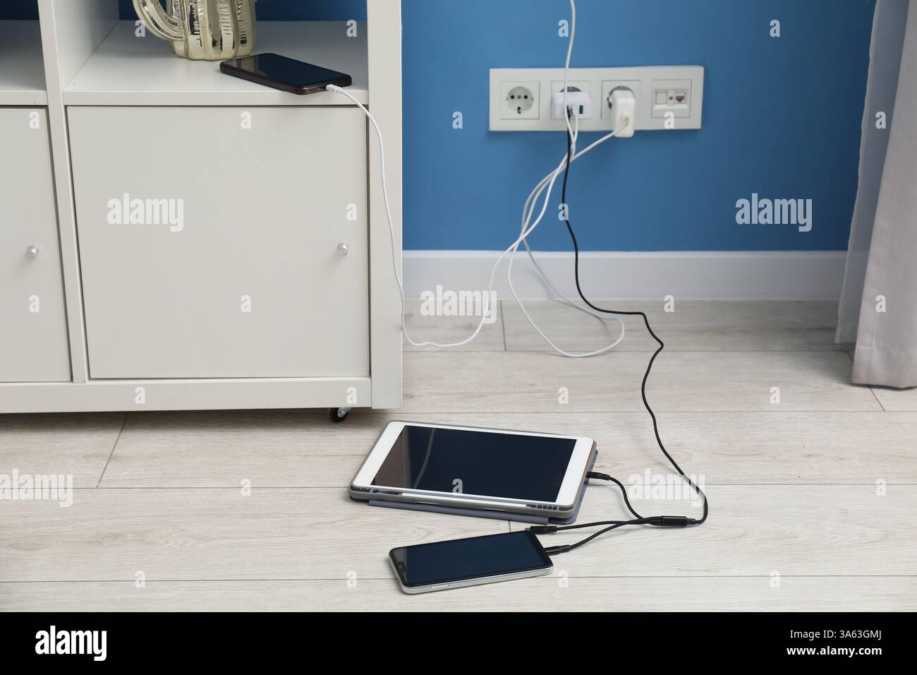 USB adapters with cables plugged into electric socket charging ...