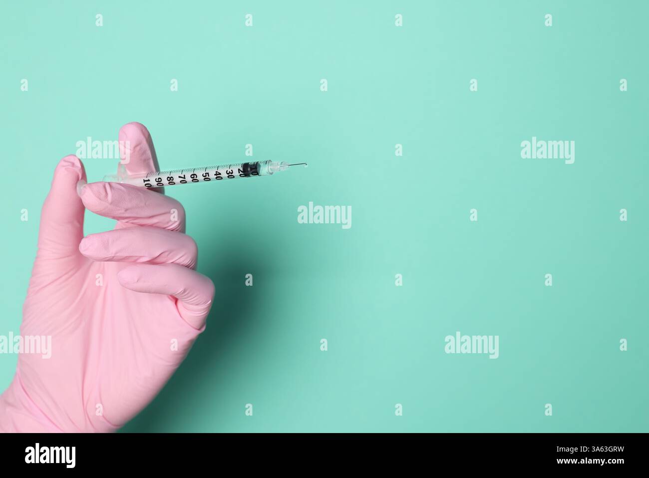 Doctor holding syringe with medication on turquoise background, closeup ...