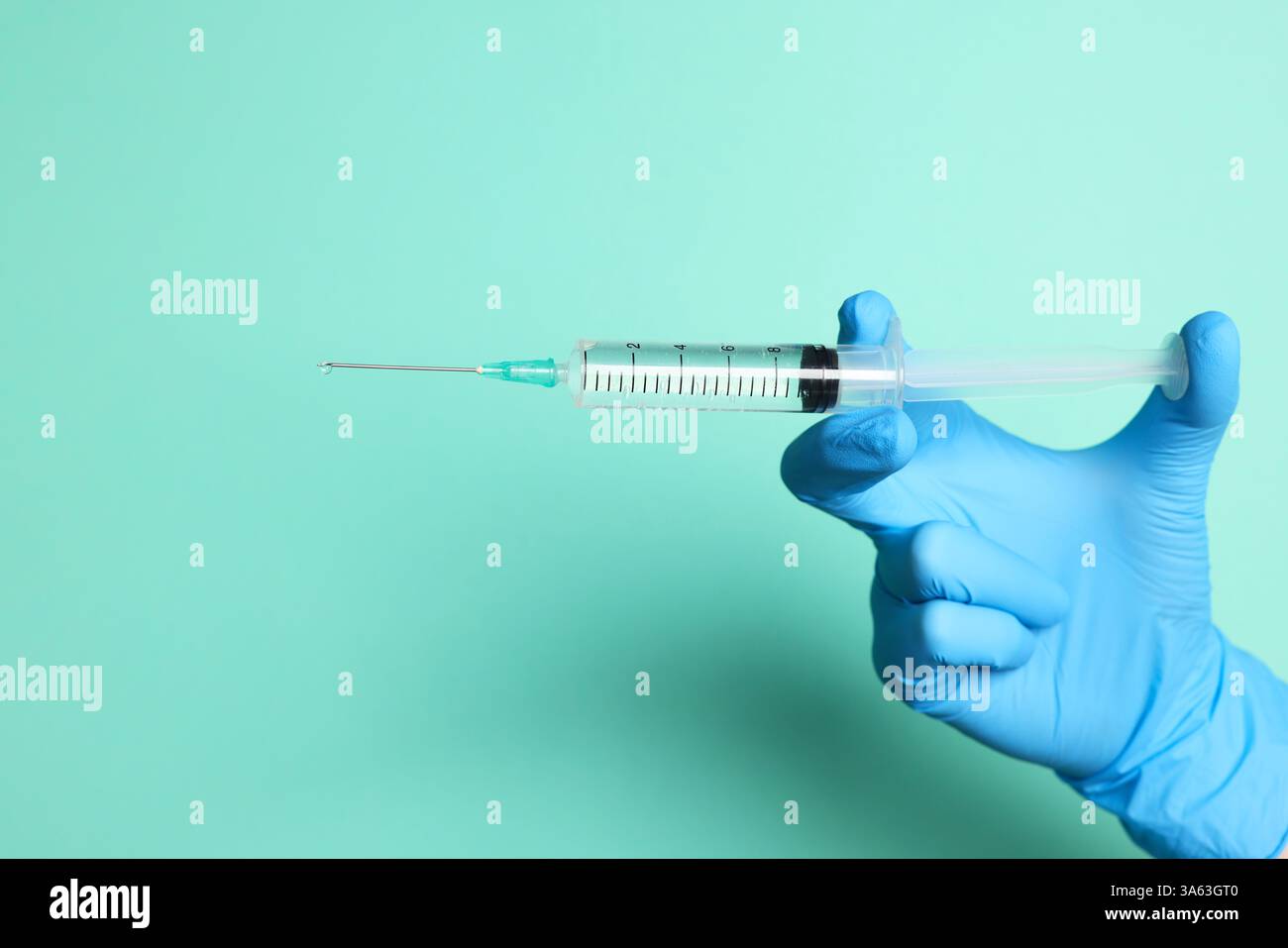 Doctor holding syringe with medication on turquoise background, closeup ...