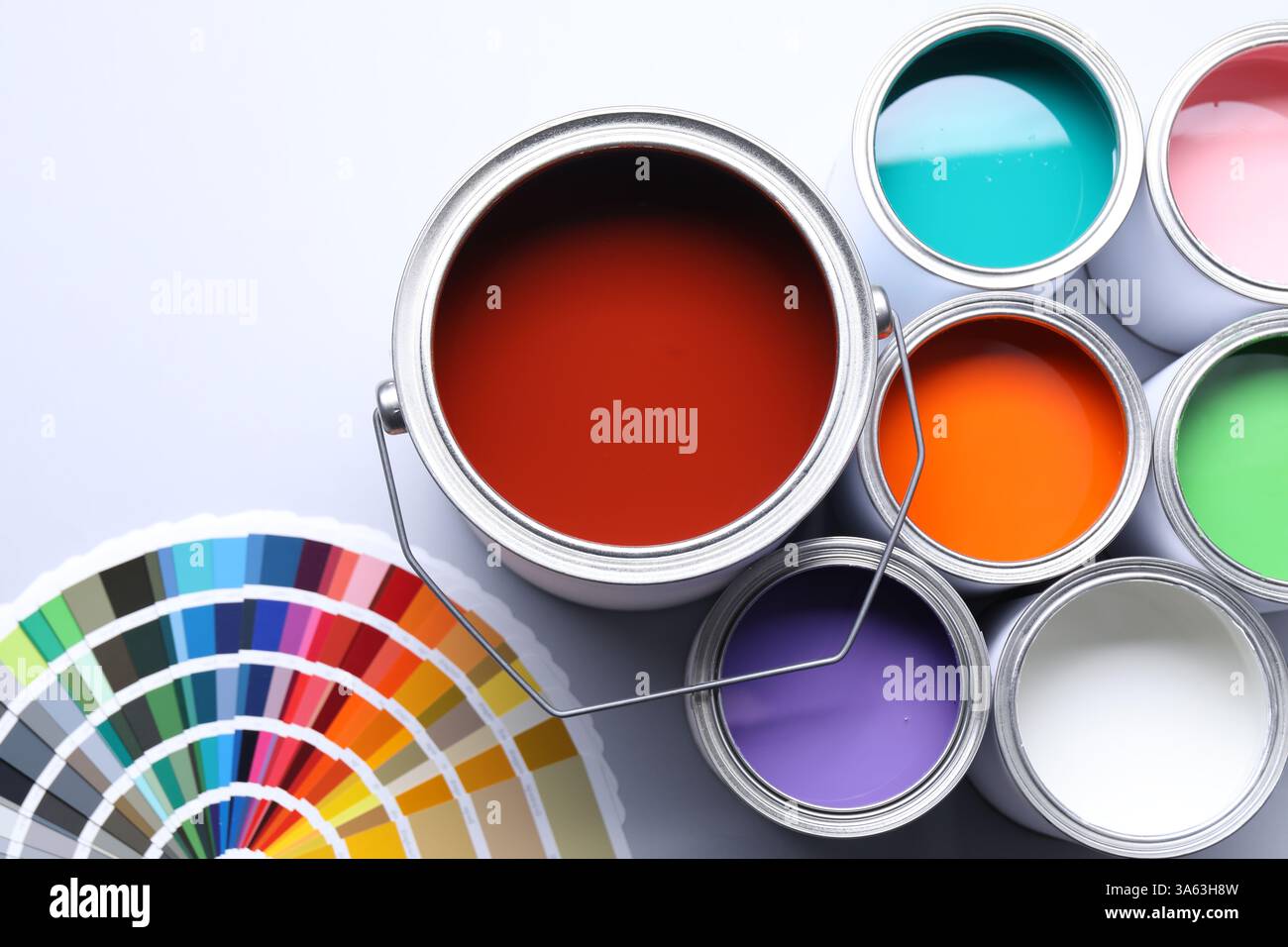 Cans of bright paints and color palettes on light background, flat lay ...