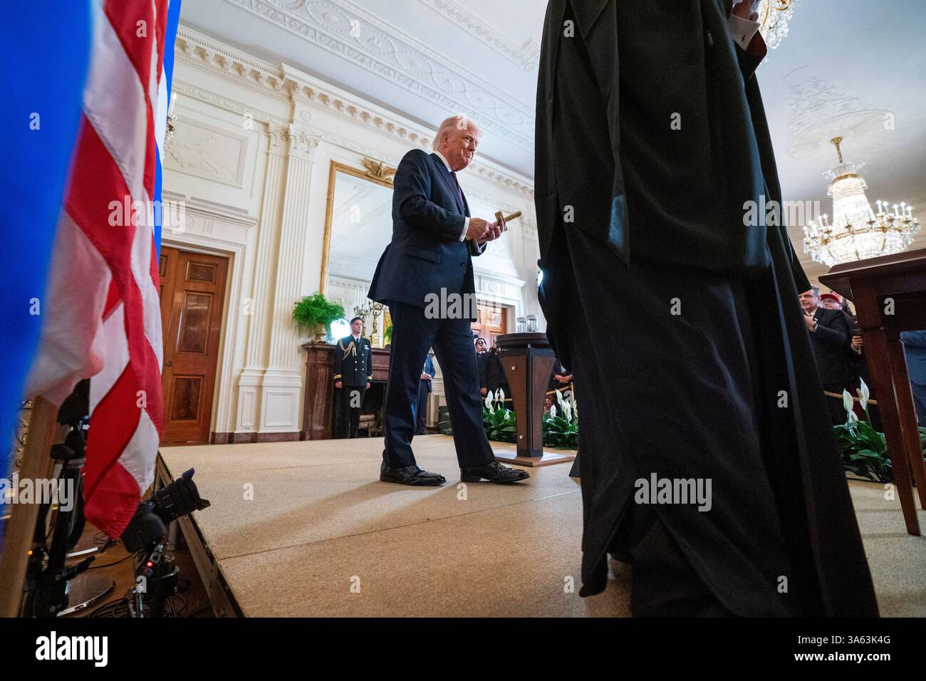 President Donald Trump, left, holds a cross gifted to him by Archbishop ...