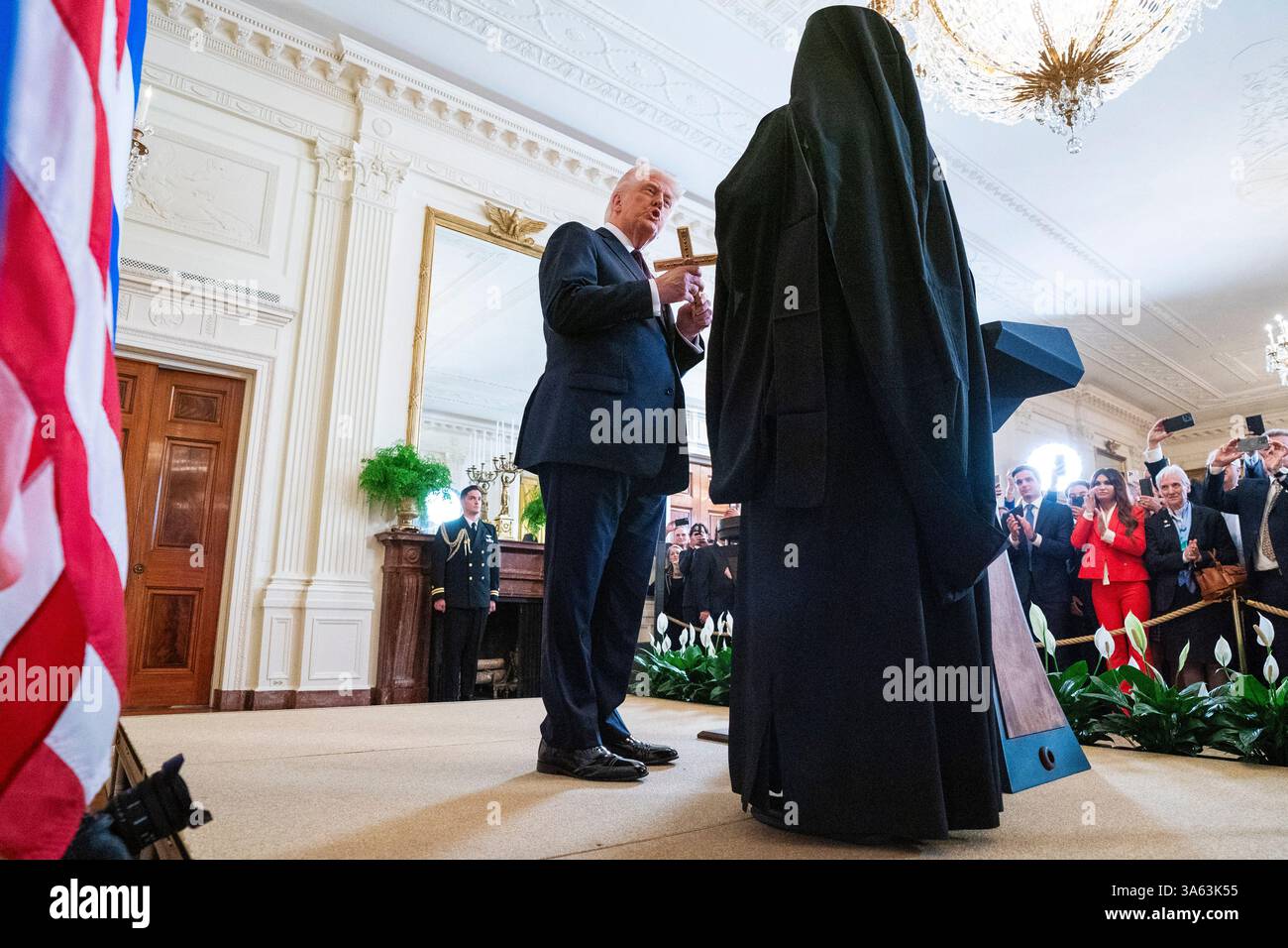 President Donald Trump, left, holds a cross gifted to him by Archbishop ...
