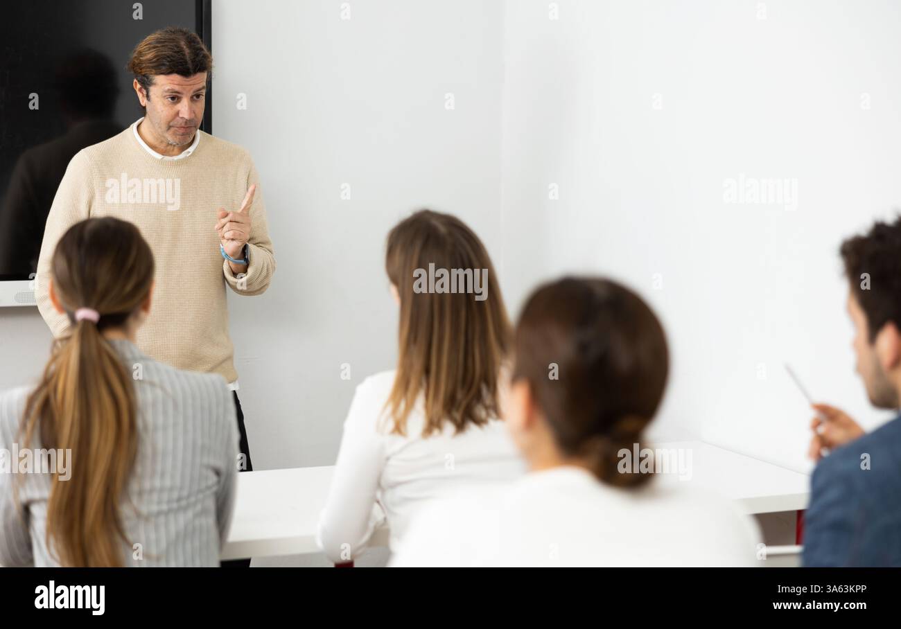 Knowledgeable professor explaining subject to classroom full of ...