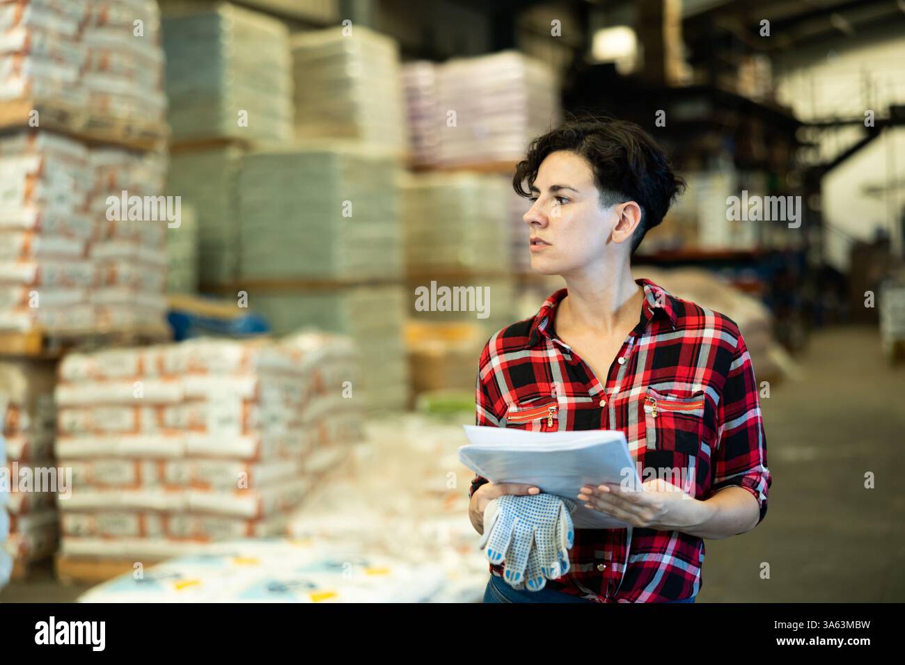 Female storekeeper checks presence of goods in the building materials ...