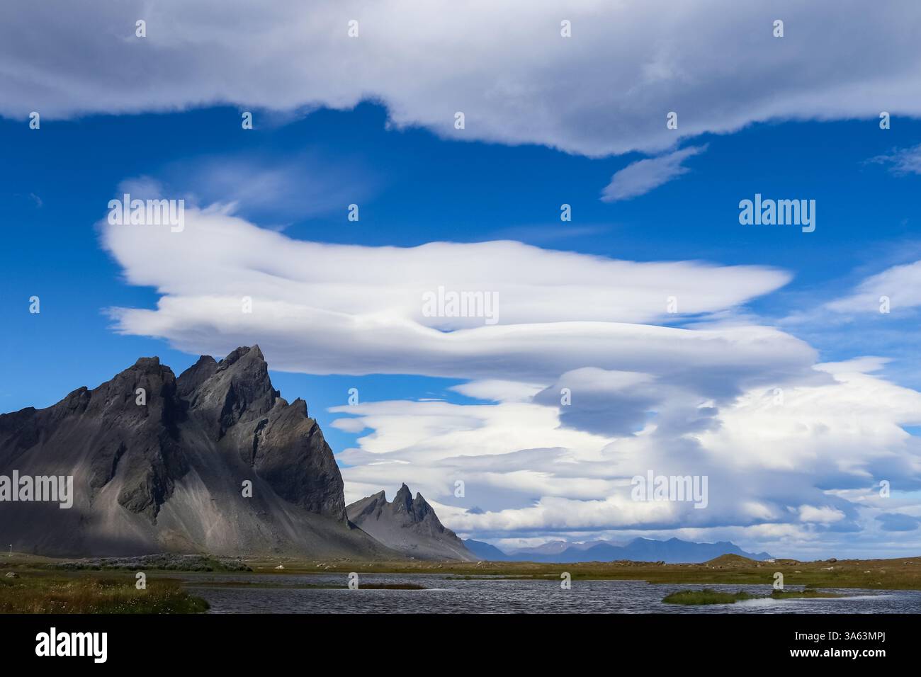 Lenticular clouds forming over a mountain range in Iceland, creating a ...