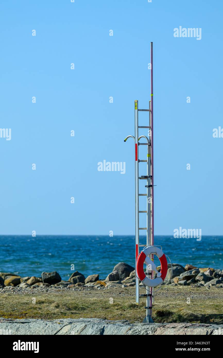 A lifeguard station stands tall with a buoy attached, positioned near ...