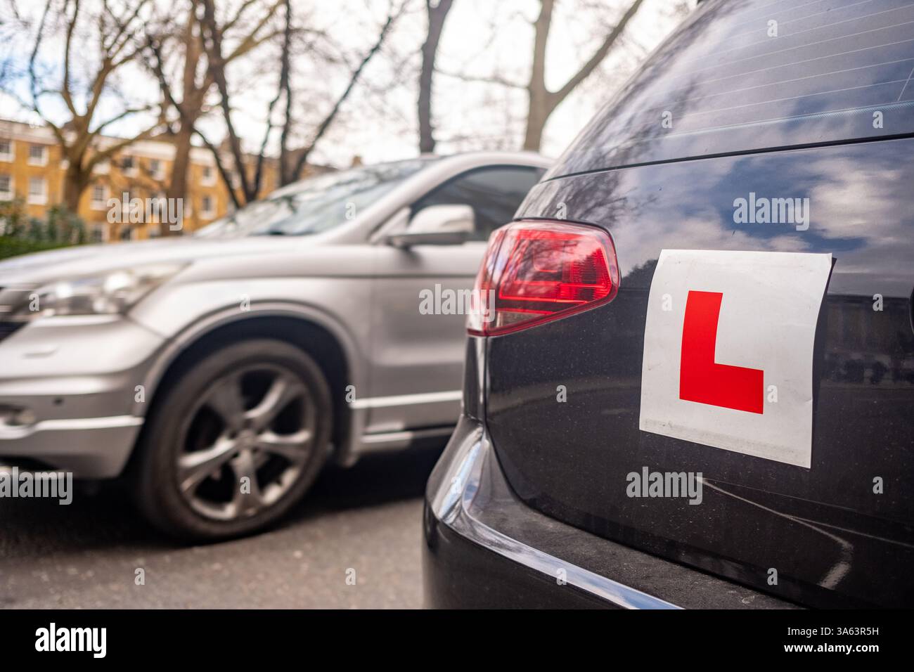 UK- Learner driver L plates attached to car on urban road in the UK ...